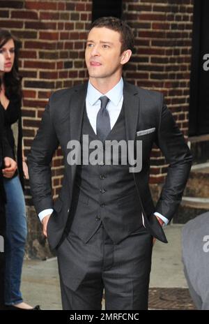 Justin Timberlake waves and flashes a thumbs up as he poses for photos ...