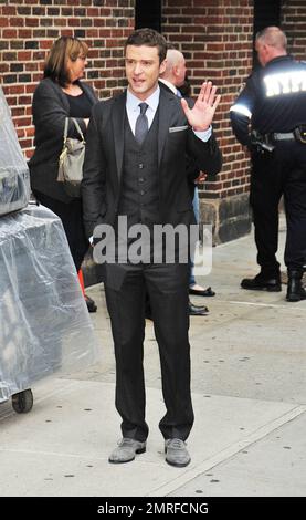 Justin Timberlake waves and flashes a thumbs up as he poses for photos ...