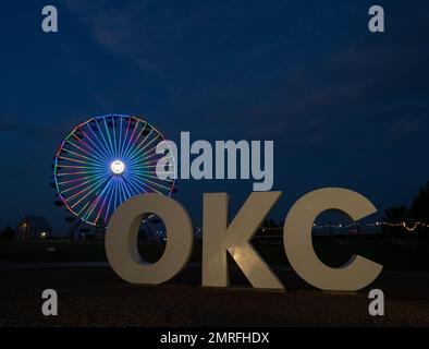 OKC sign photographed at the blue hour with the lit, stationary Wheeler ...