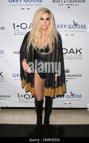 Wearing a black leather leotard under a black & gold shinny cape with ...