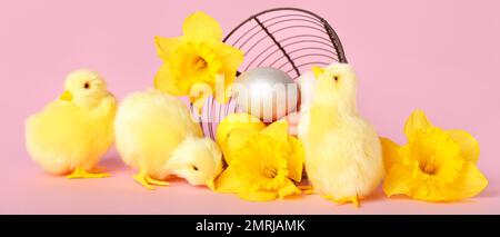 Cute chickens, overturned basket with Easter eggs and flowers on wooden ...