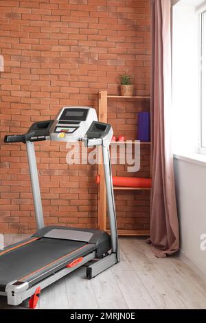 Interior of room with modern treadmill near window Stock Photo - Alamy