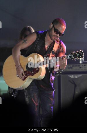 Lenny Kravitz shows off his tattoos in a sleeveless leather vest as he ...