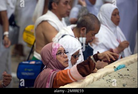 Muslim pilgrims cast stones at the huge stone pillar in the symbolic ...