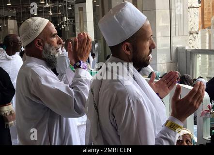 A Muslim pilgrim prays in front of the Kaaba, the cube-shaped structure ...