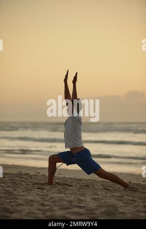 Man doing yoga on sunset with city view,Trikonasana /Triangle pose ...