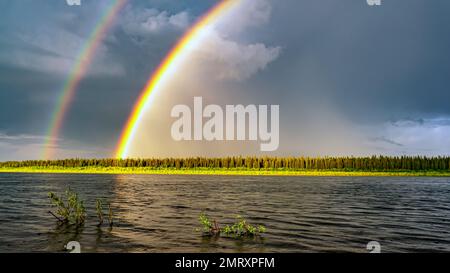 A double rainbow over the Vilyui River with raindrops against a blue ...