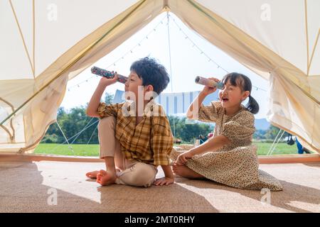 Playing two children sat in the tent Stock Photo - Alamy