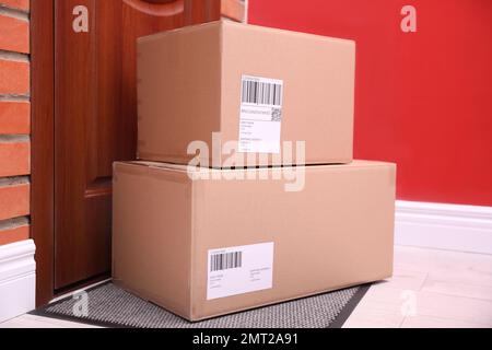 Parcels on rug near door. Delivery service Stock Photo - Alamy