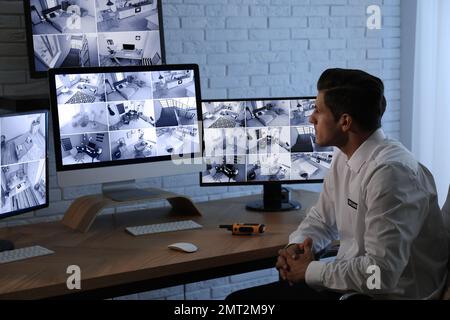 Security guard with portable transmitter monitoring modern CCTV cameras ...