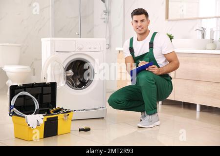 man with clipboard near washing machine Stock Photo - Alamy