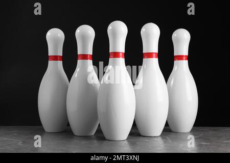Set of bowling pins on grey stone table Stock Photo - Alamy