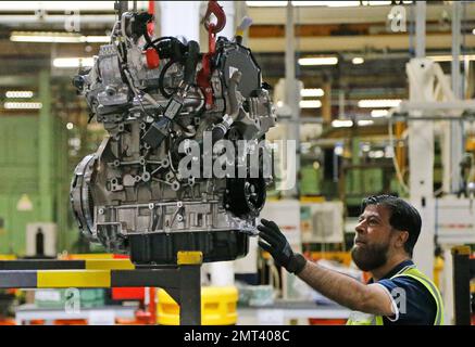A Ford employee lifts two liter diesel engines, called panther engine ...