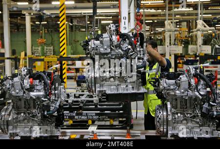 A Ford employee lifts two liter diesel engines, called panther engine ...