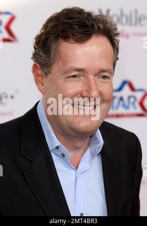 TV personality Piers Morgan poses for photographers on the pink carpet ...