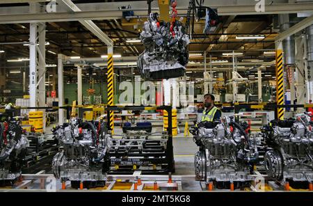 A Ford employee lifts two liter diesel engines, called panther engine ...