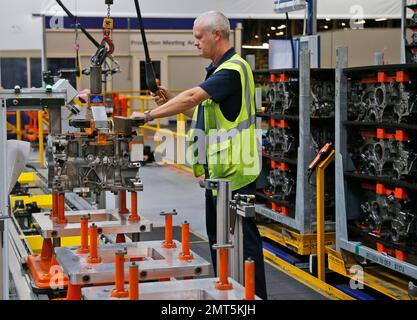 A Ford employee lifts two liter diesel engines, called panther engine ...