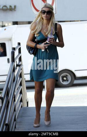 Paris Hilton talks on her cellphone and enjoys a refreshing beverage ...