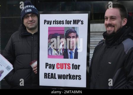 Rail workers hold up a sign with pictures of a television puppet ...