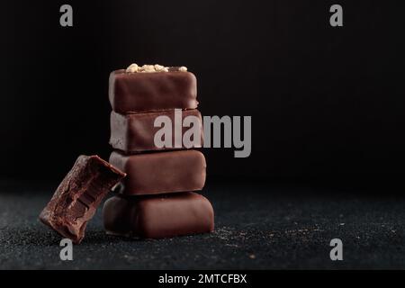 Chocolate handcrafted bonbons and bitten off piece of candy with ...
