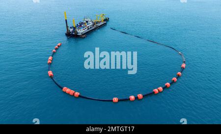 Boom floating barrier used to contain an oil spill. An offshore vessel ...
