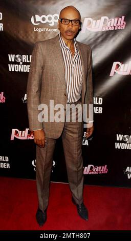 RuPaul looks sharp in a brown suit with striped shirt and glasses, a ...