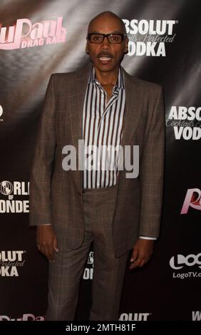 RuPaul looks sharp in a brown suit with striped shirt and glasses, a ...