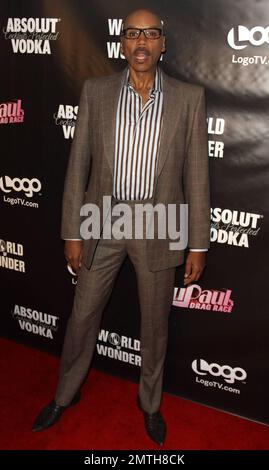 RuPaul looks sharp in a brown suit with striped shirt and glasses, a ...