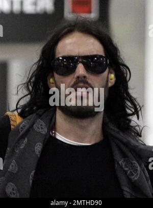 EXCLUSIVE!! English actor Russell Brand wears ear plugs as he arrives ...