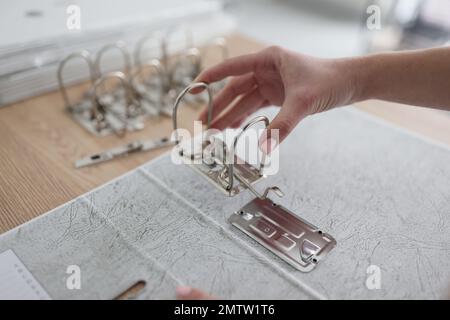 The hand inserts the ring mechanism into the folder Stock Photo - Alamy