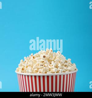 Delicious popcorn on light blue background. Space for text. Top view ...