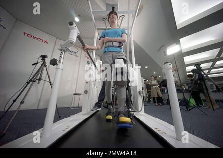 A model demonstrates the Welwalk WW-1000, a wearable robotic leg brace ...