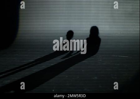 kid's shadows on wall. shadow of two children, boy and girl on striped ...