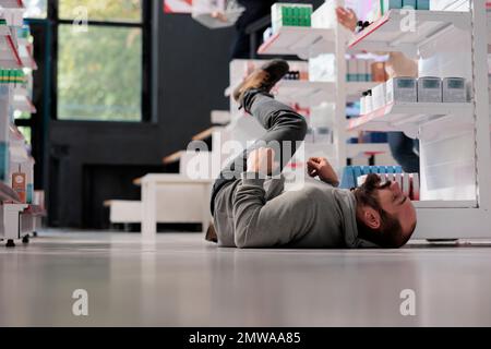 Unconscious person lying on pharmacy floor during epileptic attack ...