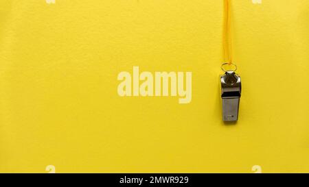 Stopwatch and whistle on a yellow background. Time management concept ...