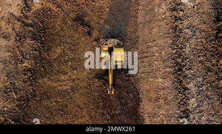 Aerial view of a wheel loader excavator with a backhoe loading sand ...