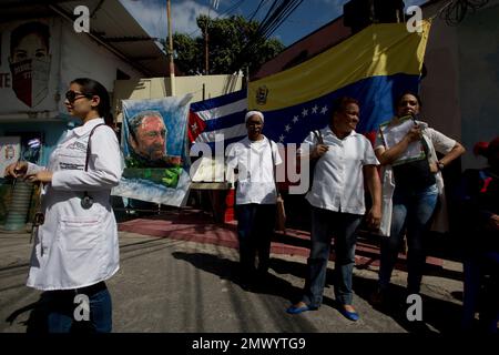 Cuban doctors working in Venezuela, hold a photo of Cuba's former ...