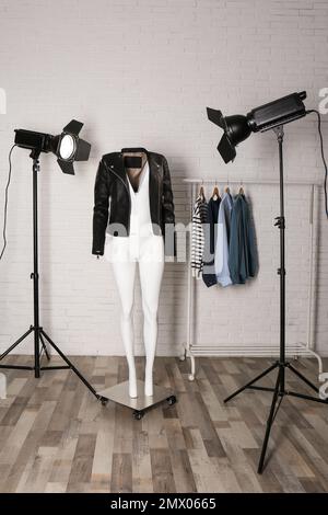 Stylish clothes on ghost mannequin and professional lighting equipment ...