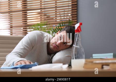 Lazy man procrastinating while cleaning at home Stock Photo - Alamy