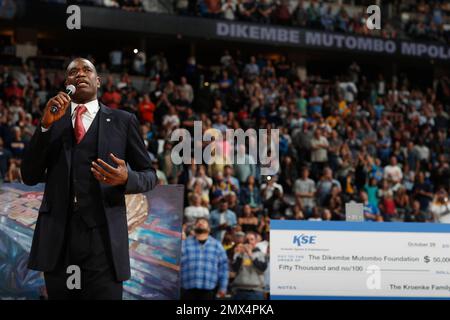 Retired Denver Nuggets center Dikembe Mutombo waves to the crowd as his ...