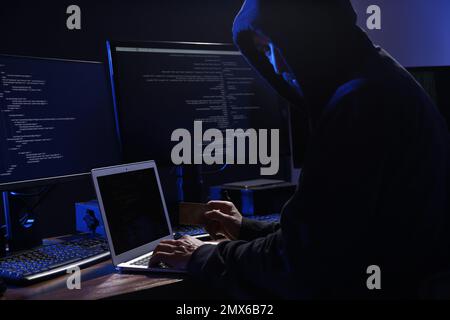 Hacker with computers and credit card in dark room. Cyber crime Stock ...