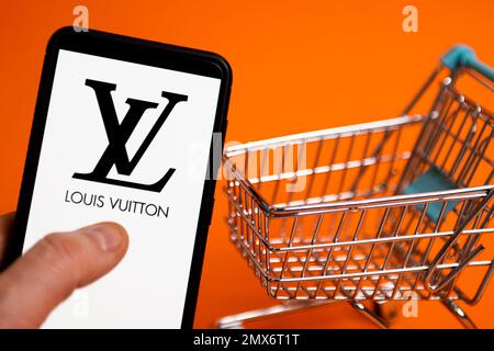 In this photo illustration, a Louis Vuitton logo seen displayed on a ...