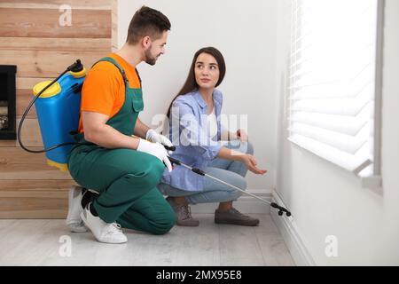 Woman showing insect traces to pest control worker at home Stock Photo ...