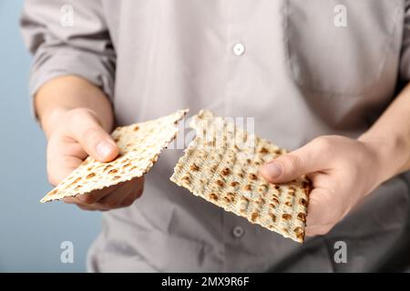 Man with Matzo on grey background, closeup. Pesach (Passover ...