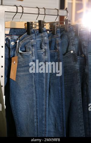 Rack with pants in modern shop, closeup Stock Photo - Alamy