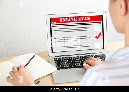 Student passing online exam at wooden table, closeup Stock Photo - Alamy