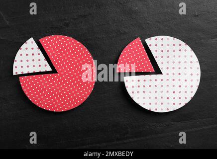 Paper circles with exchanged segments on black slate background, flat ...