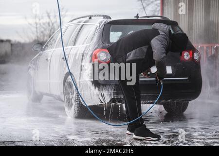 the car at the car wash is covered with foam, wash under pressure with ...