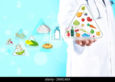 Nutritionist and food pyramid on light blue background, closeup Stock ...