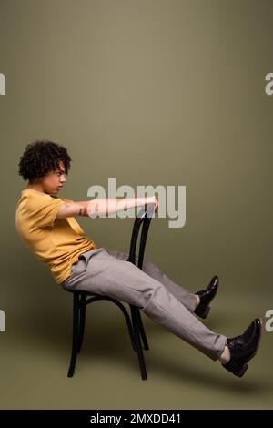 Side view of stylish tattooed african american woman standing on urban ...